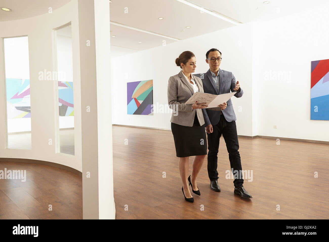 Male asian worker and caucasian female manager in gallery of printing ...