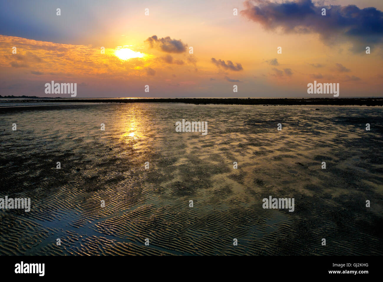 Colourful sunrise and the sand during low tide ocean water Stock Photo ...