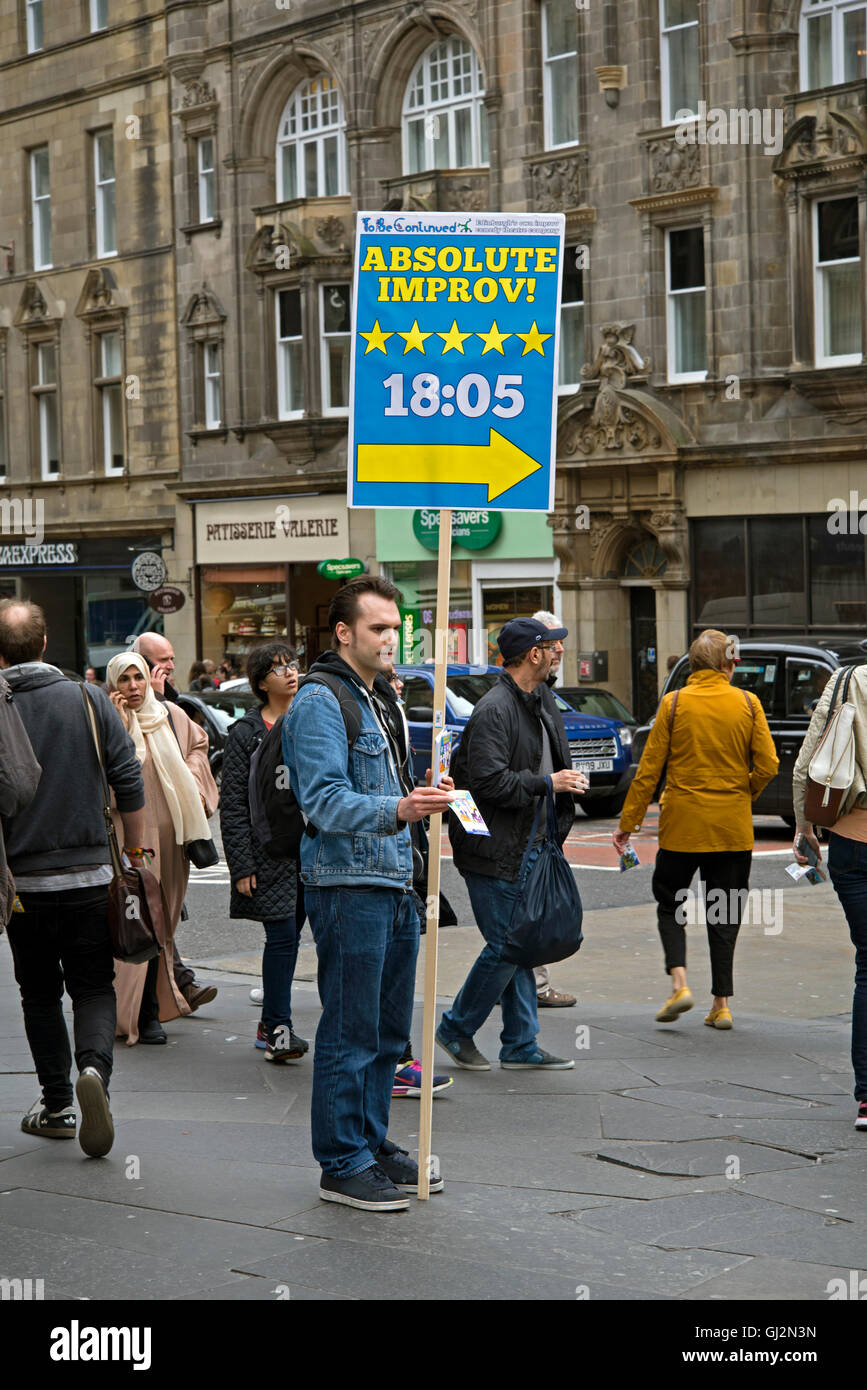 Young man holding a sign and handing out fliers advertising "Absolute ...