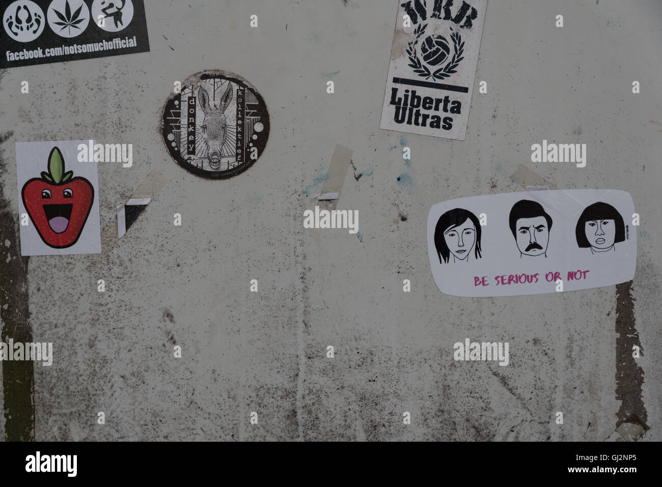 Random odd stickers on a wall in Bruges, Belgium Stock Photo - Alamy