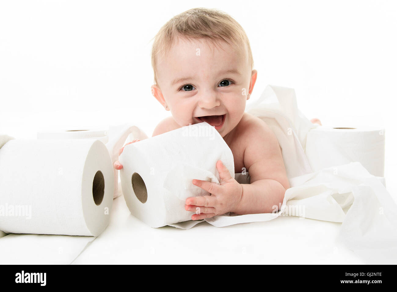 A Toddler ripping up toilet paper in bathroom studio Stock Photo - Alamy