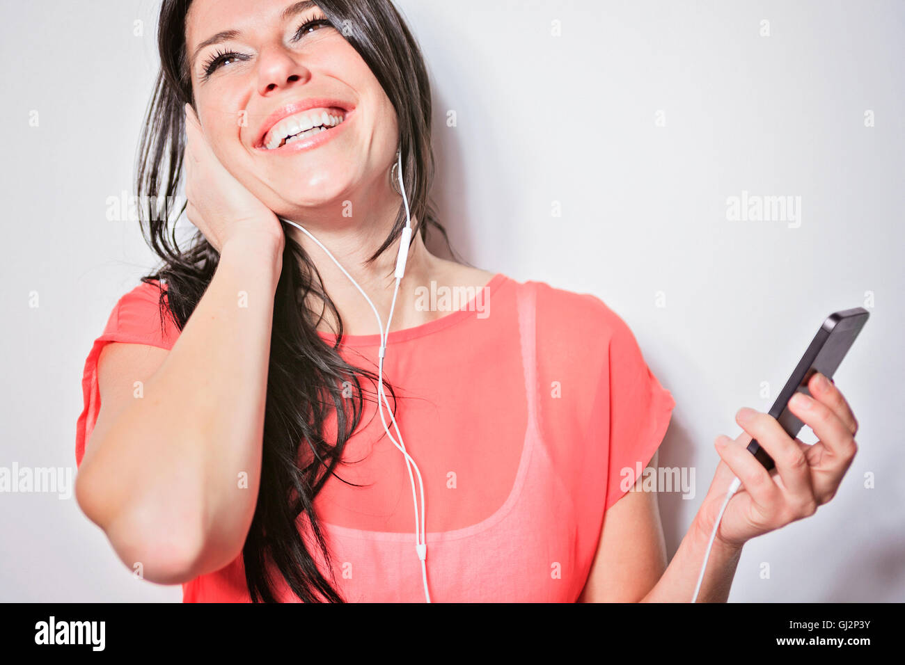 A woman having fun listening music on grey background Stock Photo - Alamy
