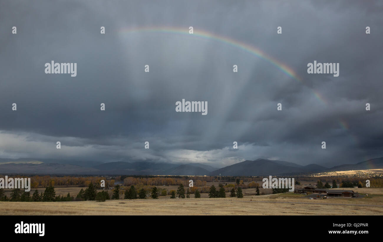 Rainbow forming over valley Stock Photo - Alamy