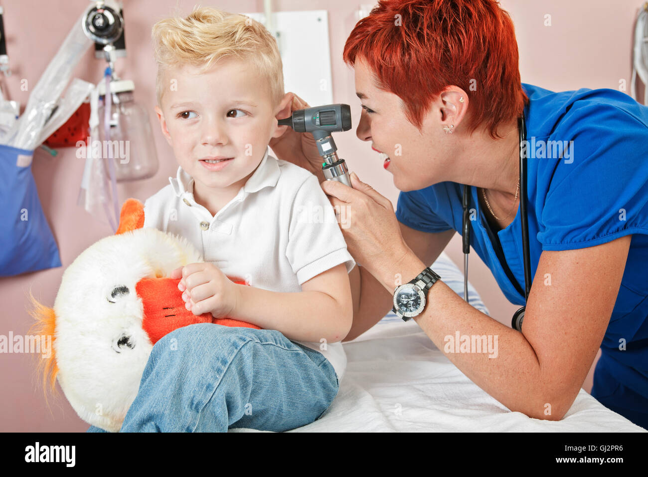 A Doctor Examining the ear of a cute little boy Stock Photo - Alamy