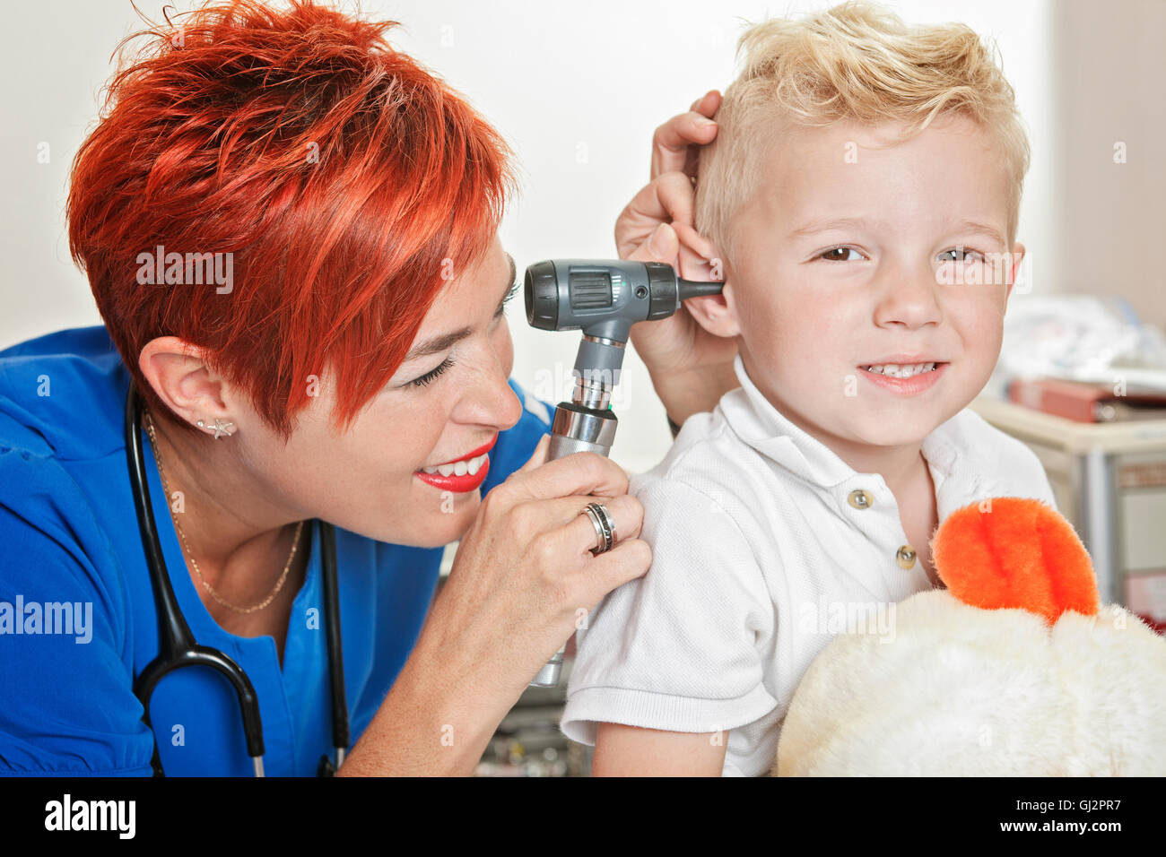 A Doctor Examining the ear of a cute little boy Stock Photo - Alamy