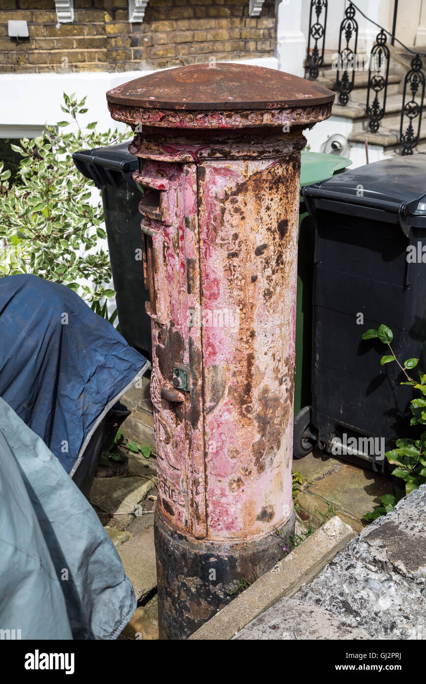 Old, faded and decaying British red post box seen in London, UK Stock ...