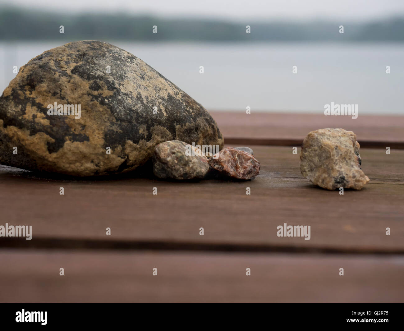 Rocks on picnic table by lake Stock Photo - Alamy