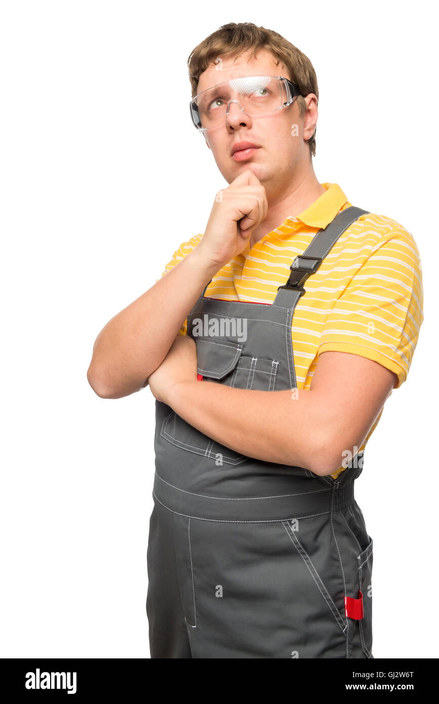 Vertical portrait of a pensive mechanic in overalls on a white ...