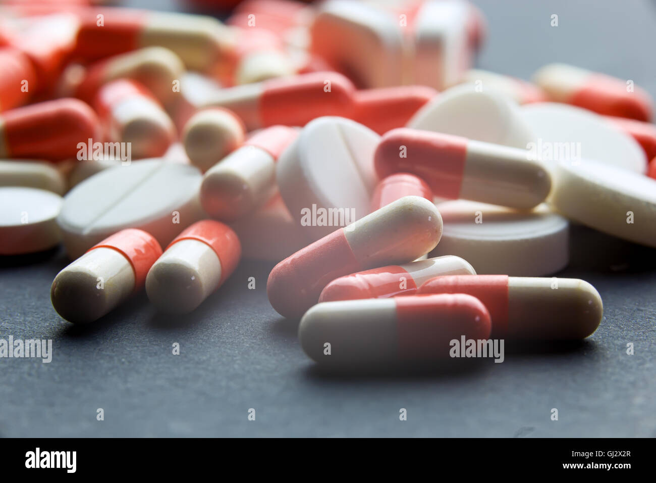 Pharmacy theme Heap of red orange white round capsule pills with ...