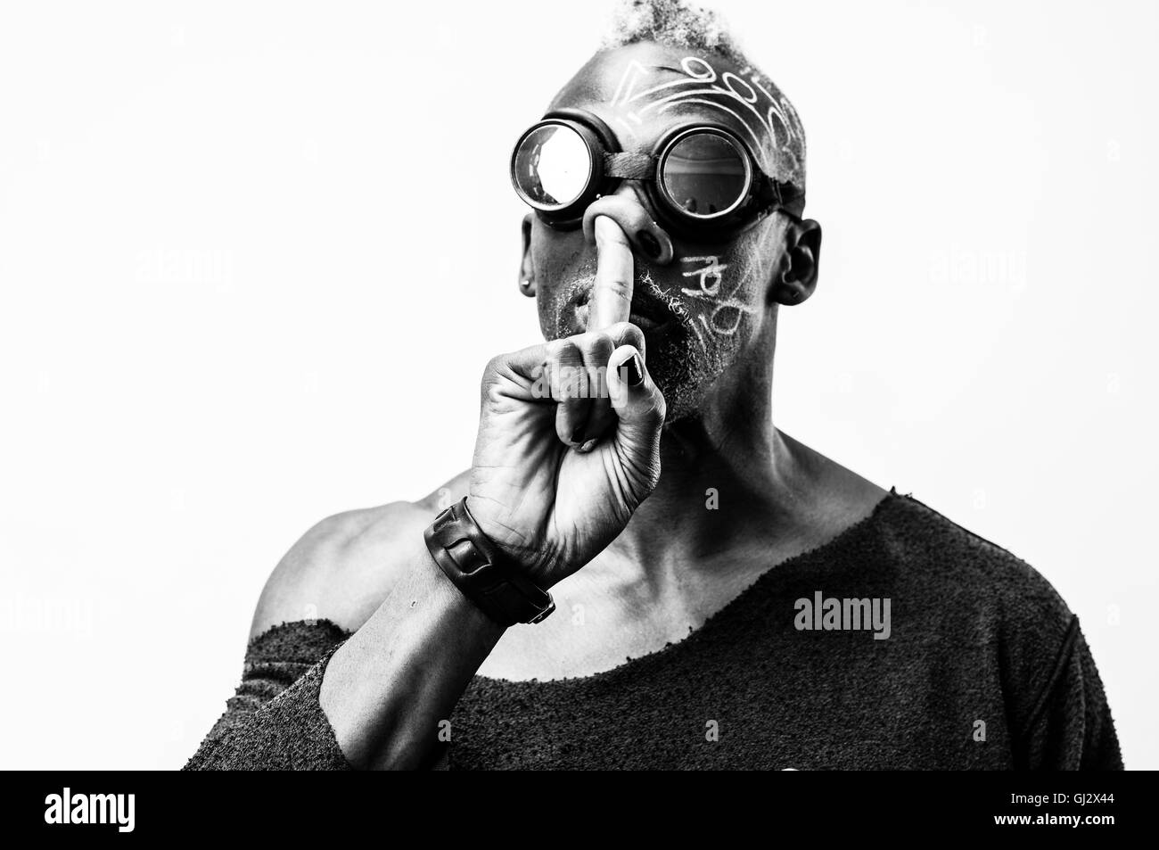 black-white portrait of male black model wearing goggles with finger in ...