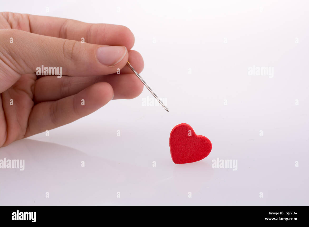 Hand pointing a needle on a heart Stock Photo - Alamy