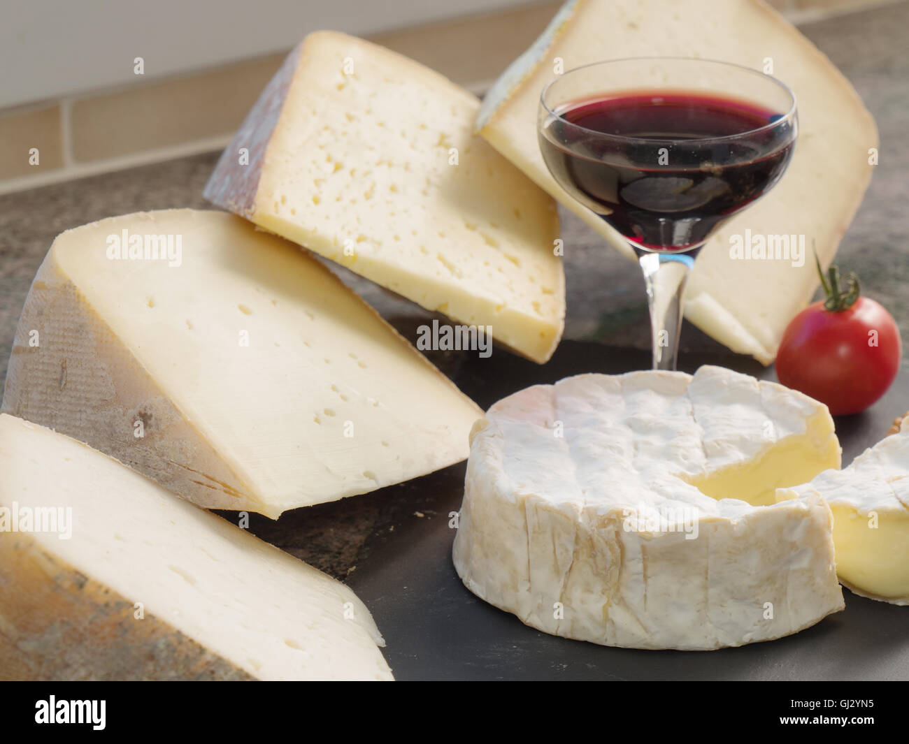 the different french cheeses with a glass of red wine Stock Photo - Alamy