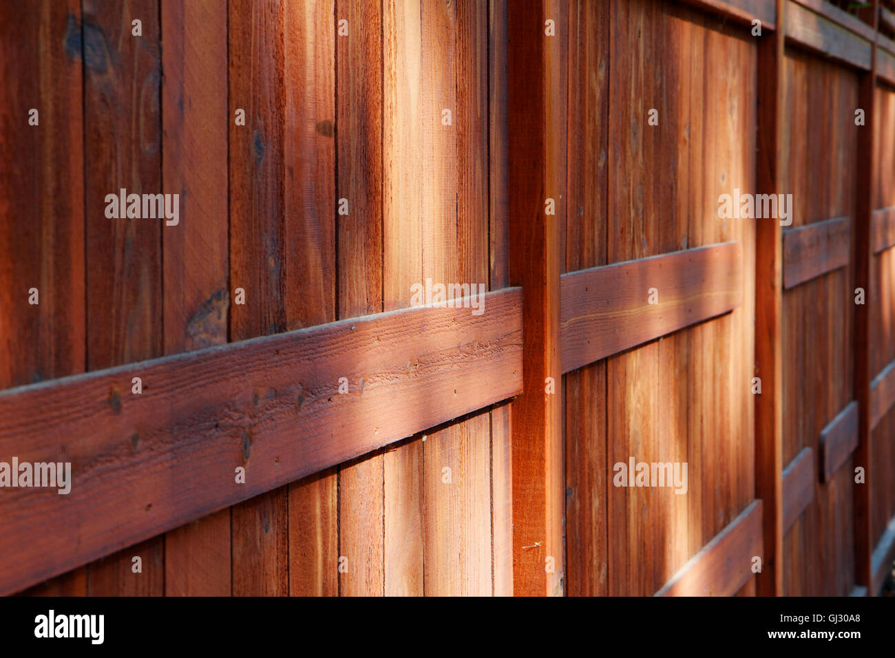 Stained redwood fence perspective Stock Photo - Alamy