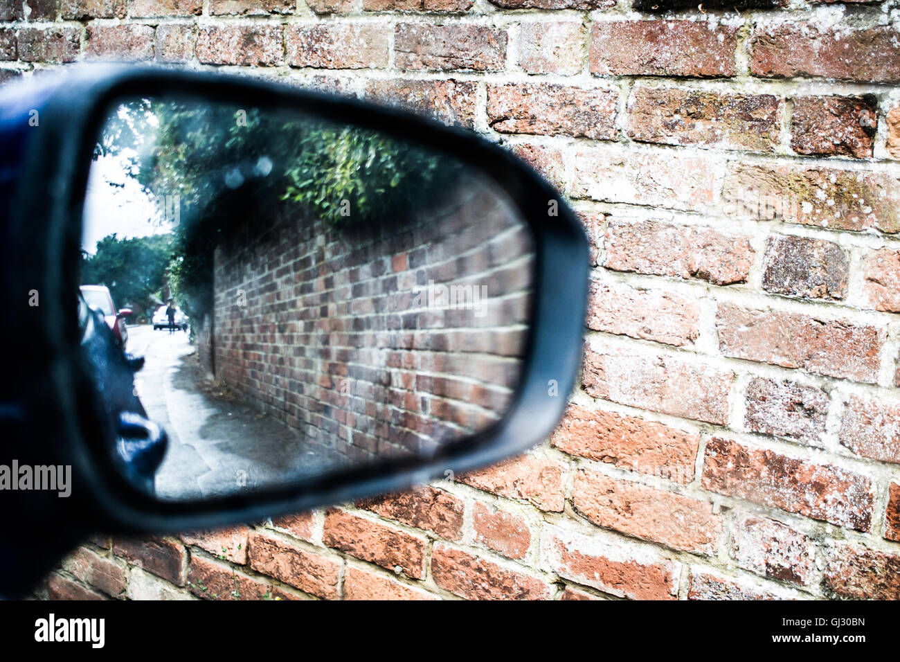 Brick wall forward and back through the side mirror of a car Stock ...