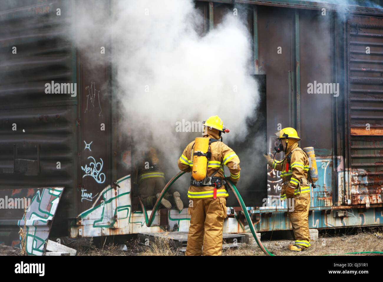 Firemen working to put out fire Stock Photo - Alamy