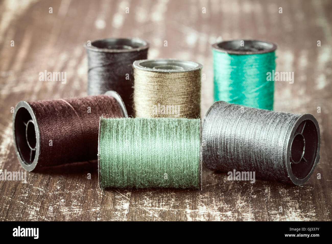 Bobbins with colorful threads on wooden background Stock Photo - Alamy