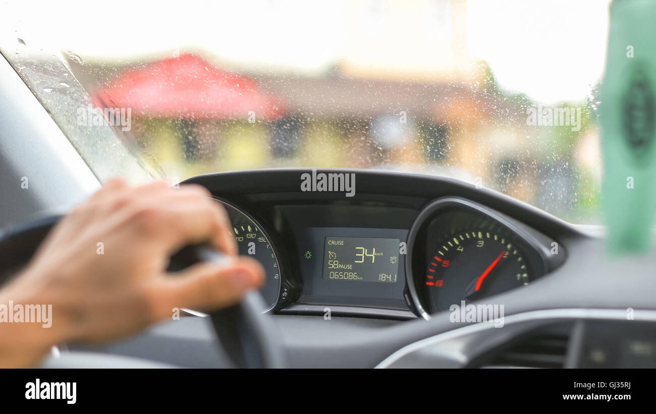Caucasian man driving a car and placing his hand slowly on the wheel ...