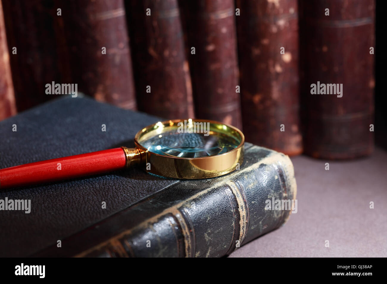 Vintage library. Magnifying glass on old books background Stock Photo ...