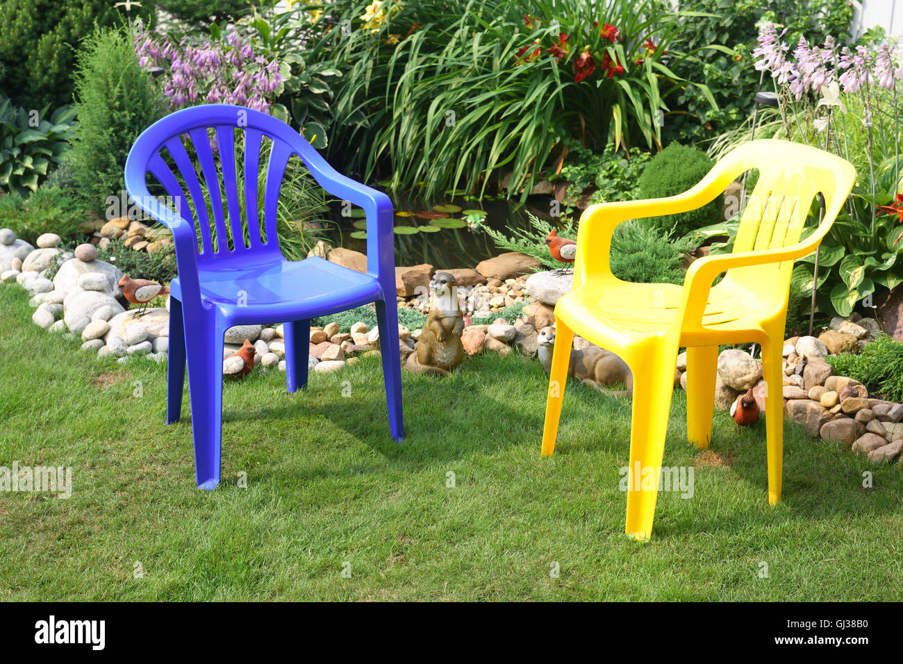 Blue and yellow plastic chairs in garden under sunlight Stock Photo - Alamy