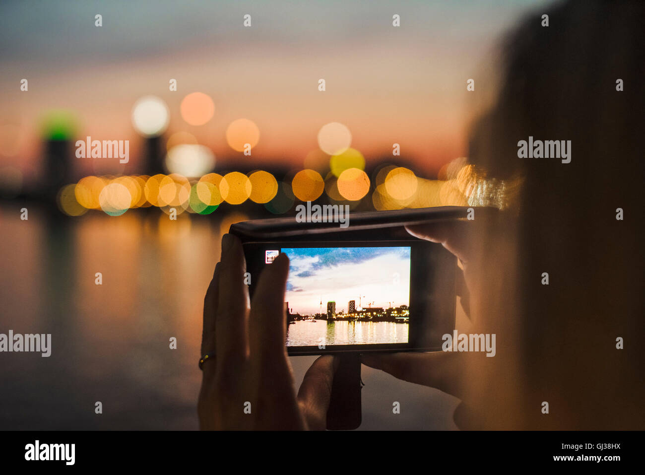 Young woman photographing view with smartphone, close-up of screen ...