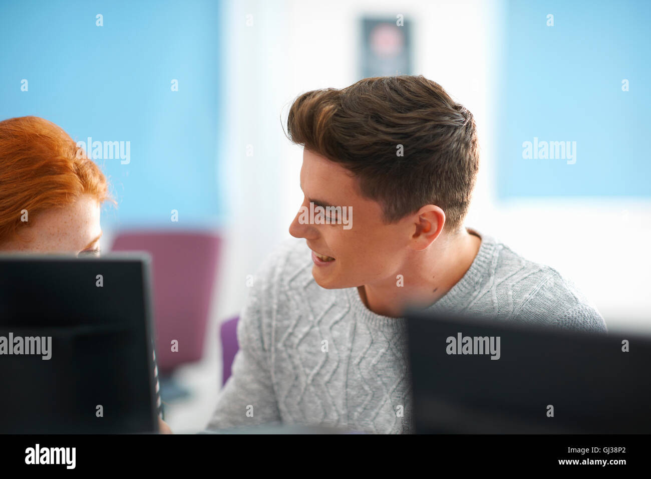 Young male and female college students having discussion at computer ...