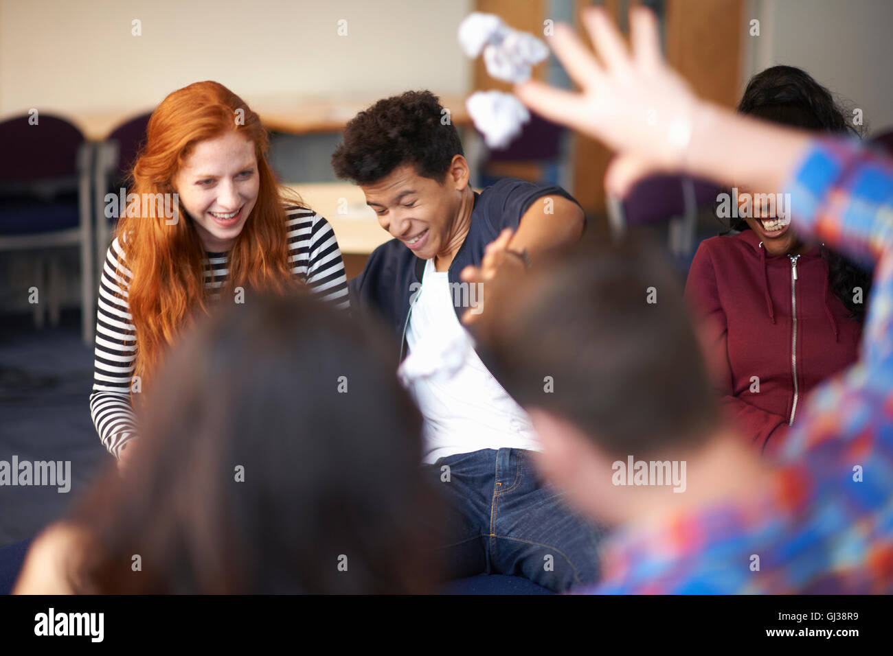 Young male students throwing crumpled paper in common room Stock Photo ...