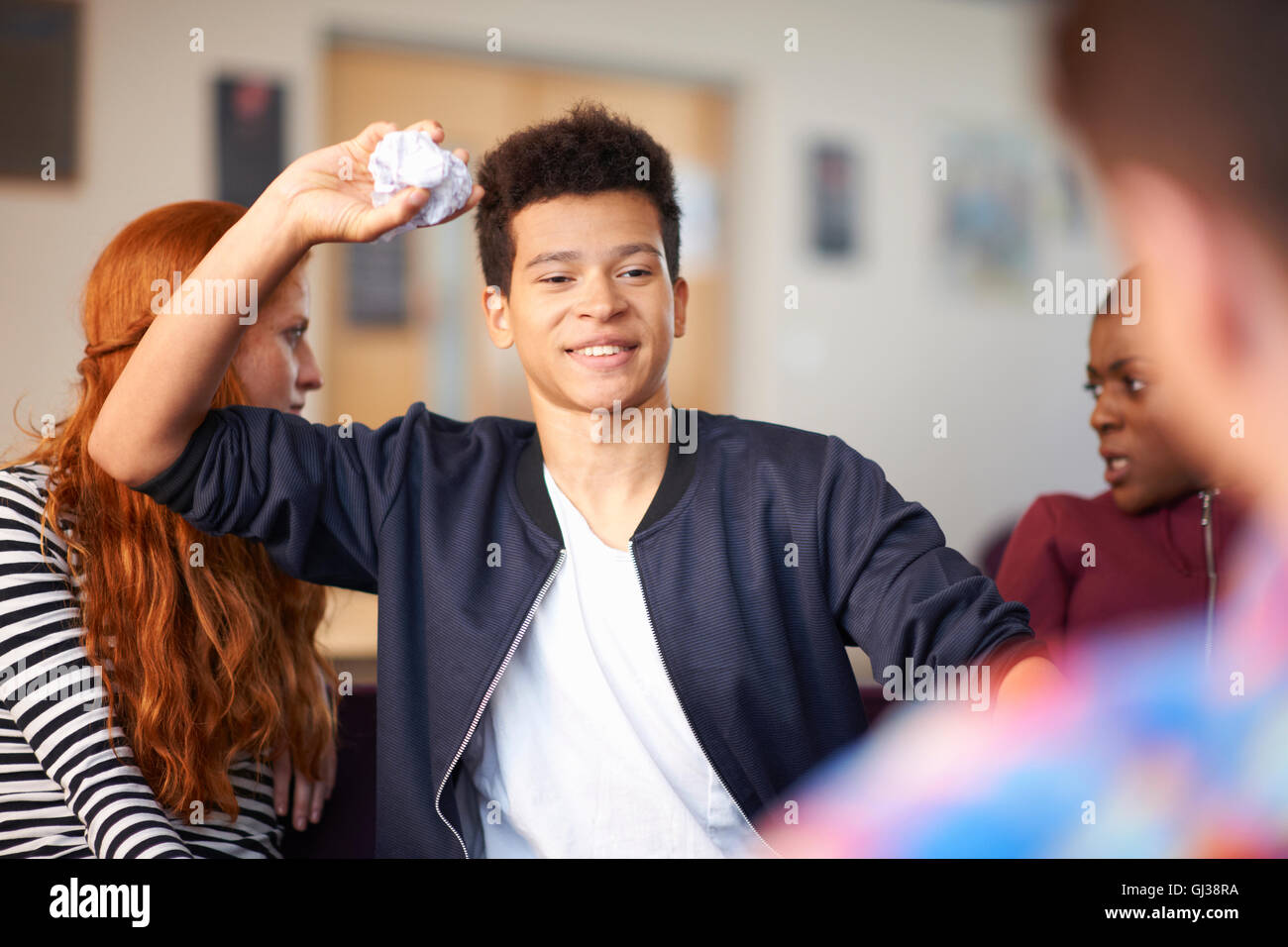 Male students throwing crumpled paper in common room Stock Photo - Alamy