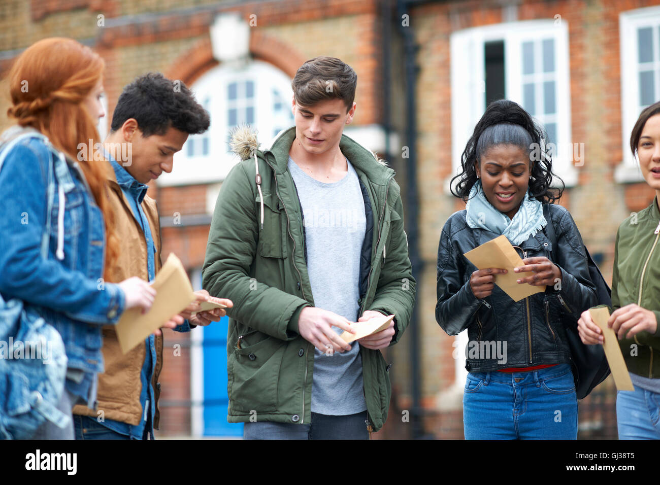 Young adult college students opening exam results on campus Stock Photo ...