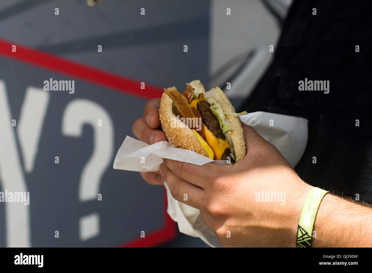 Male customer's hand eating hamburger from fast food van Stock Photo ...
