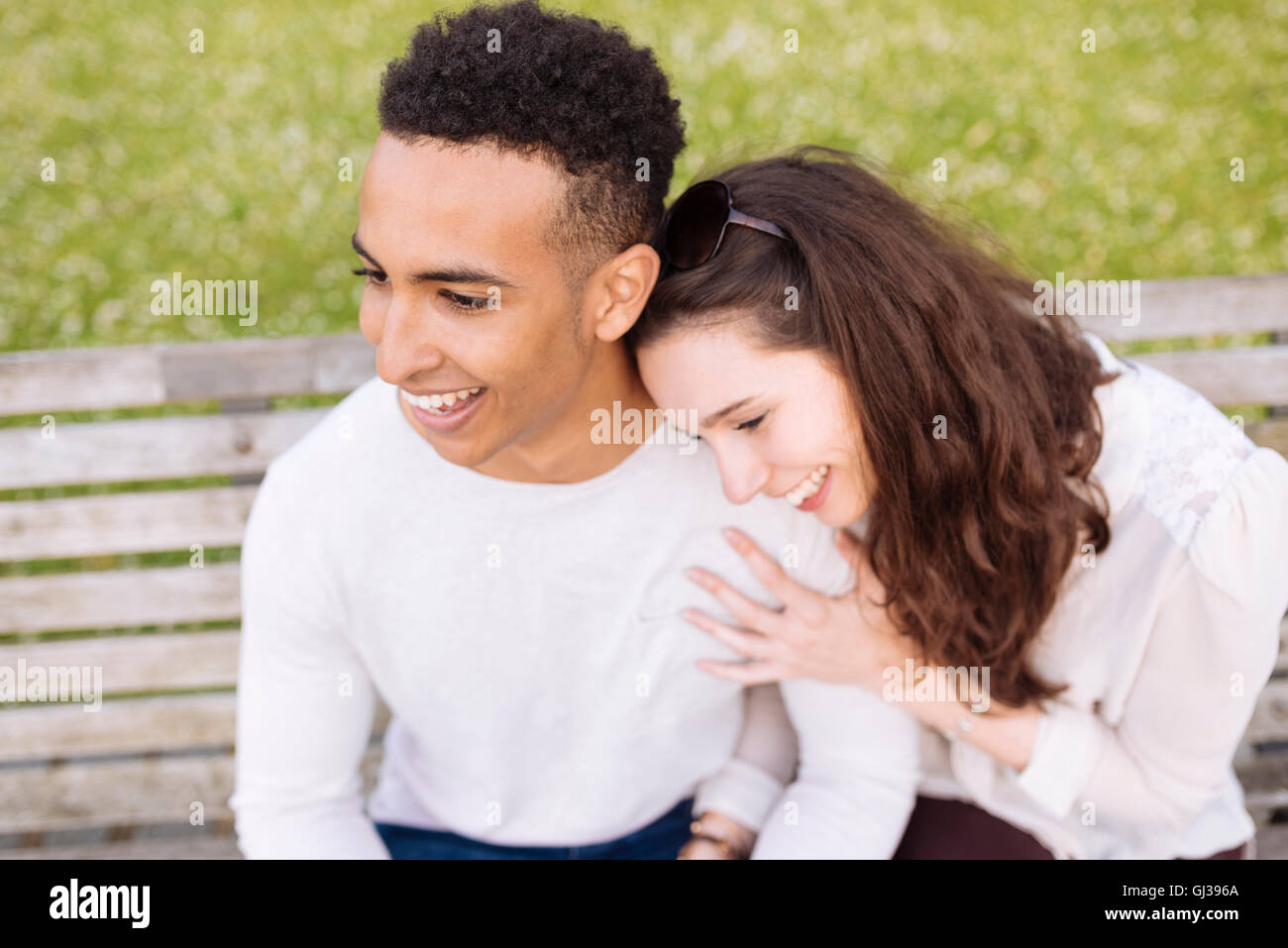 High angle view of young couple sitting on park bench smiling Stock ...