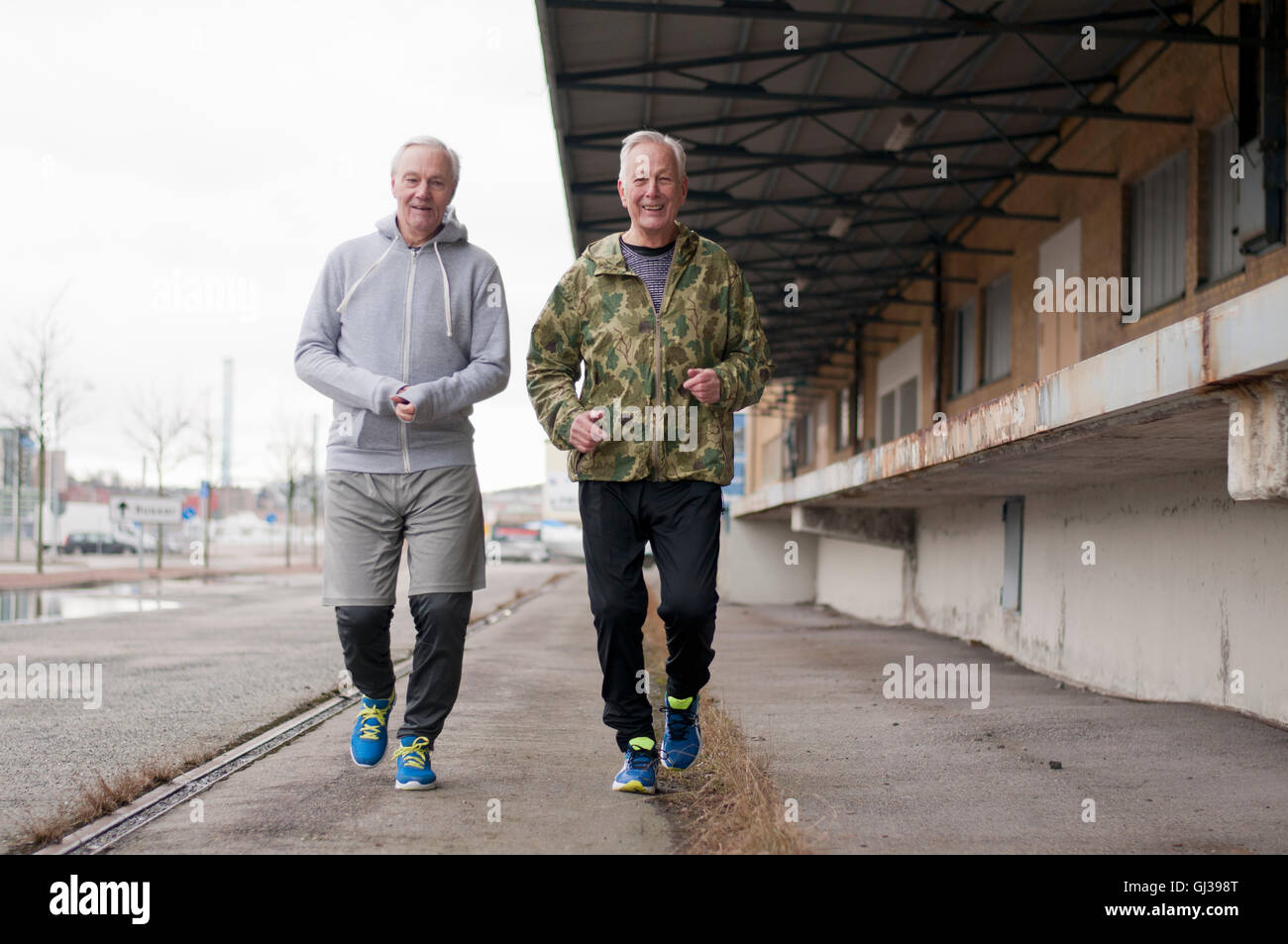 Senior friends wearing sports clothes jogging side by side Stock Photo ...