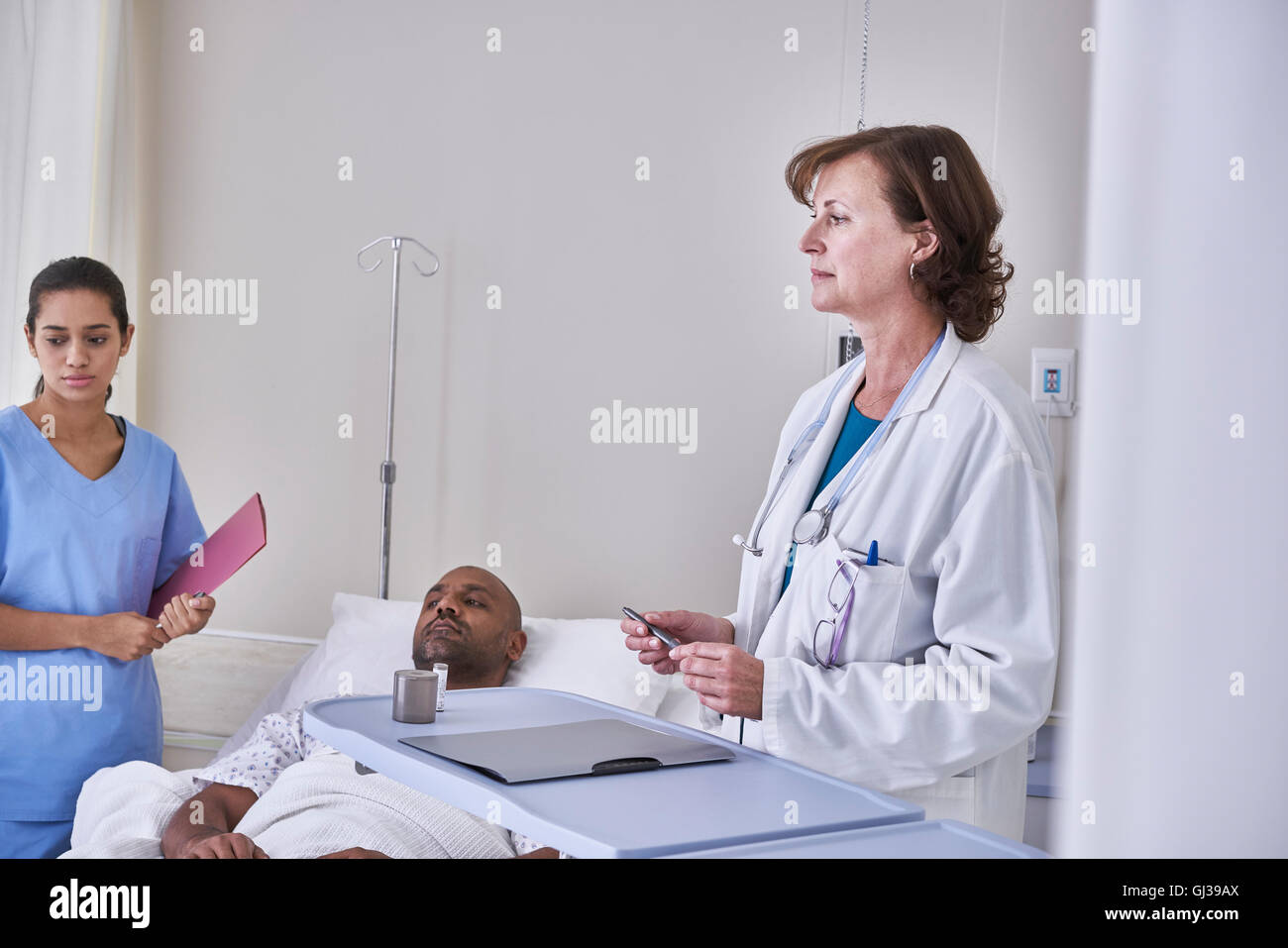 Doctors diagnosing patient lying in hospital bed Stock Photo - Alamy