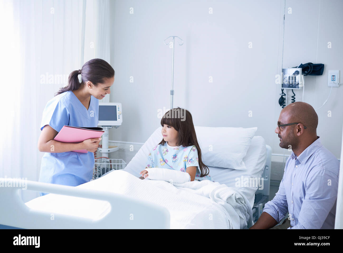 Female nurse explaining to girl patient with arm plaster cast in ...
