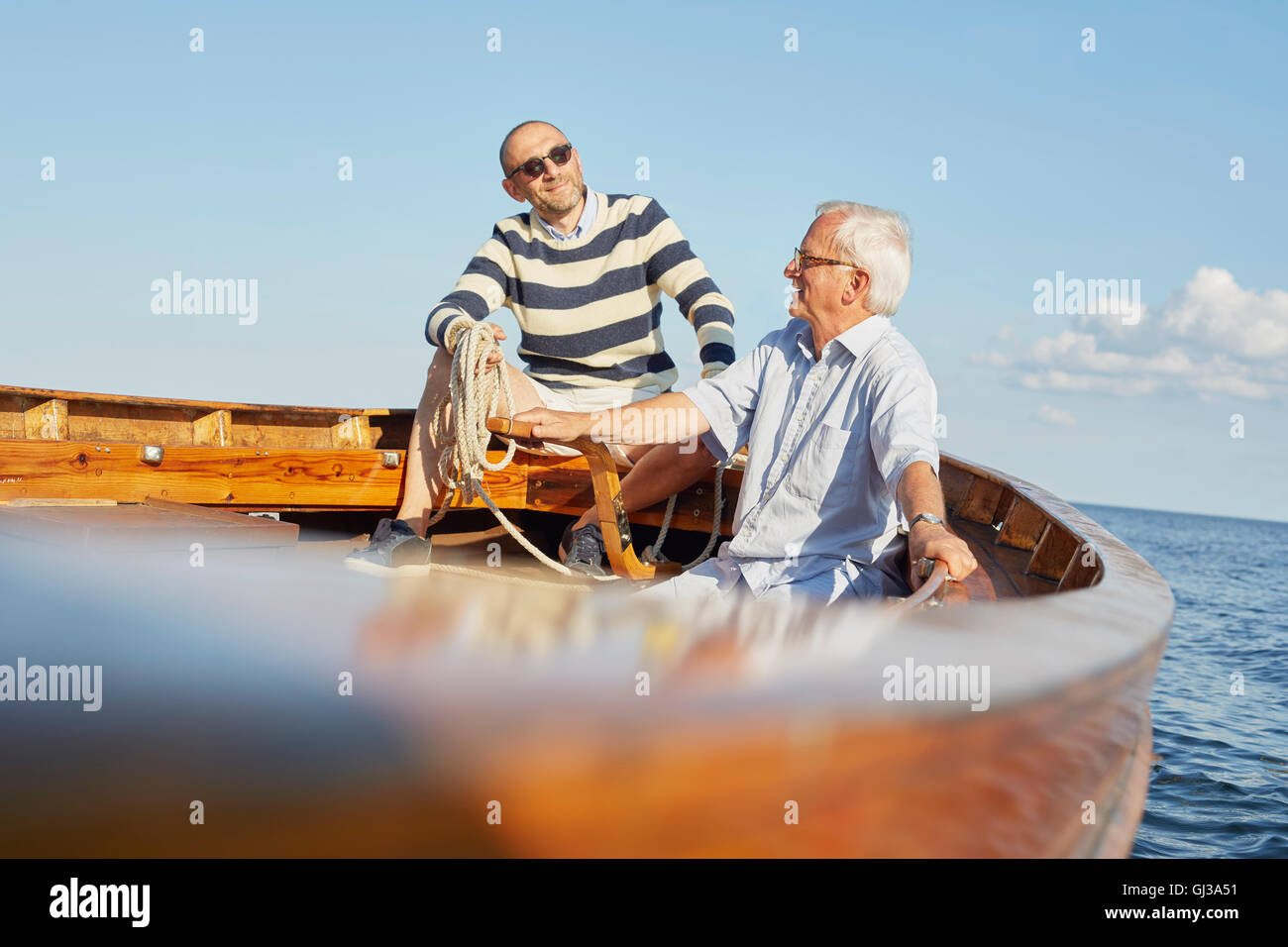 Friends sitting in boat Stock Photo - Alamy