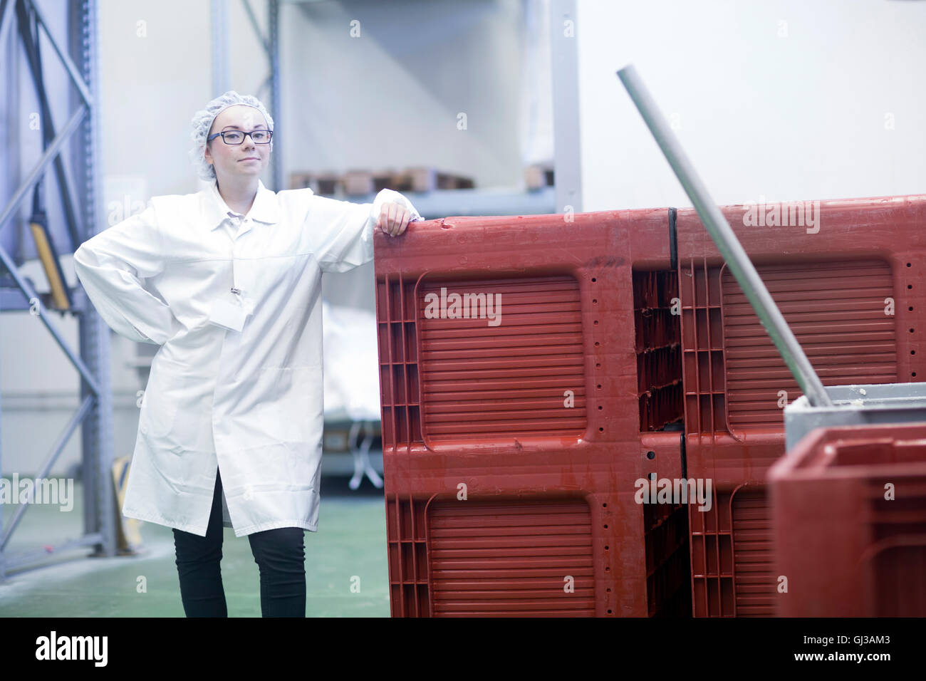 Factory worker wearing overall and hair net looking at camera Stock ...