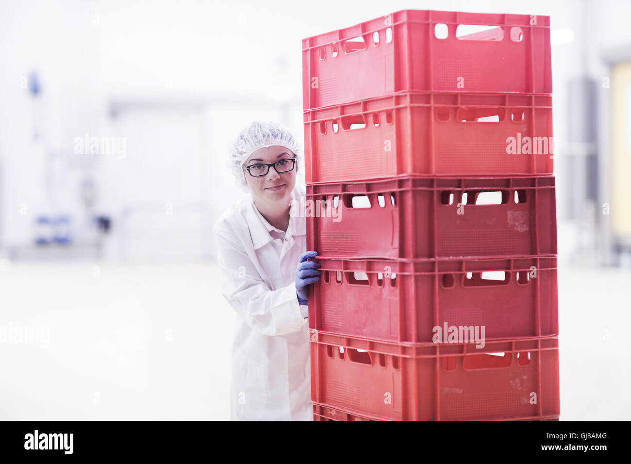 Factory worker pushing stacked crates Stock Photo - Alamy