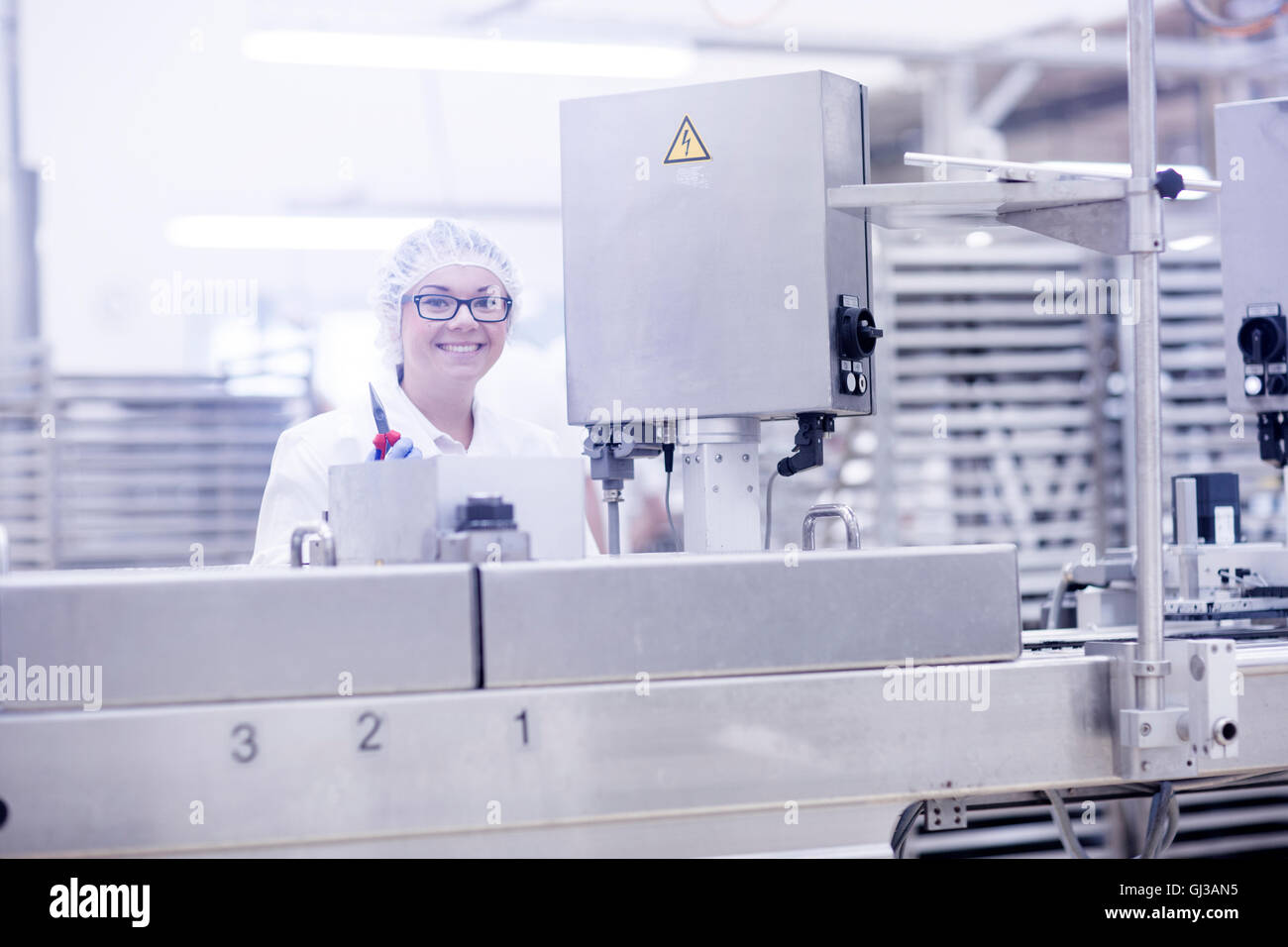 Factory worker operating food production machinery Stock Photo - Alamy