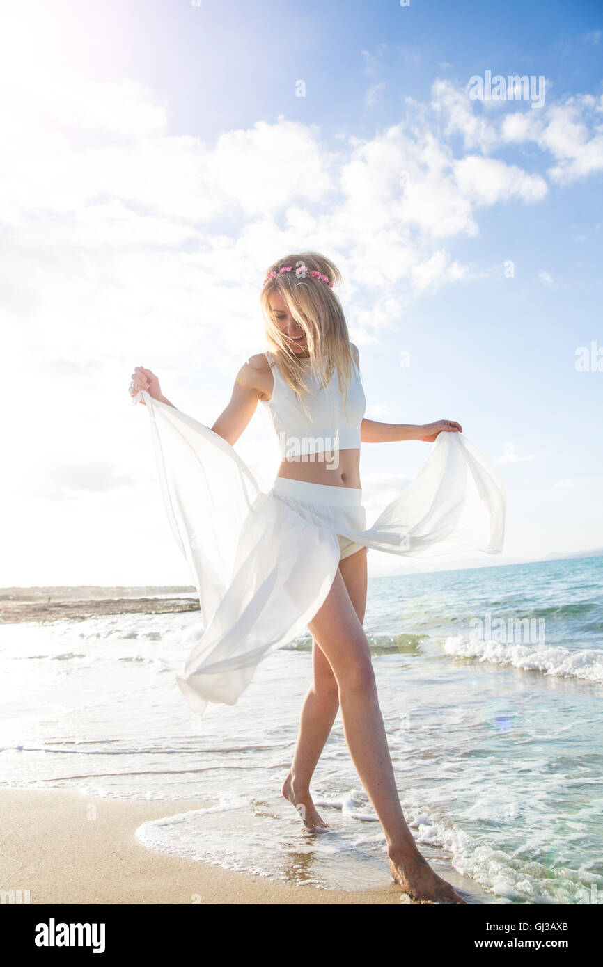 Young woman on beach, dancing, smiling Stock Photo - Alamy