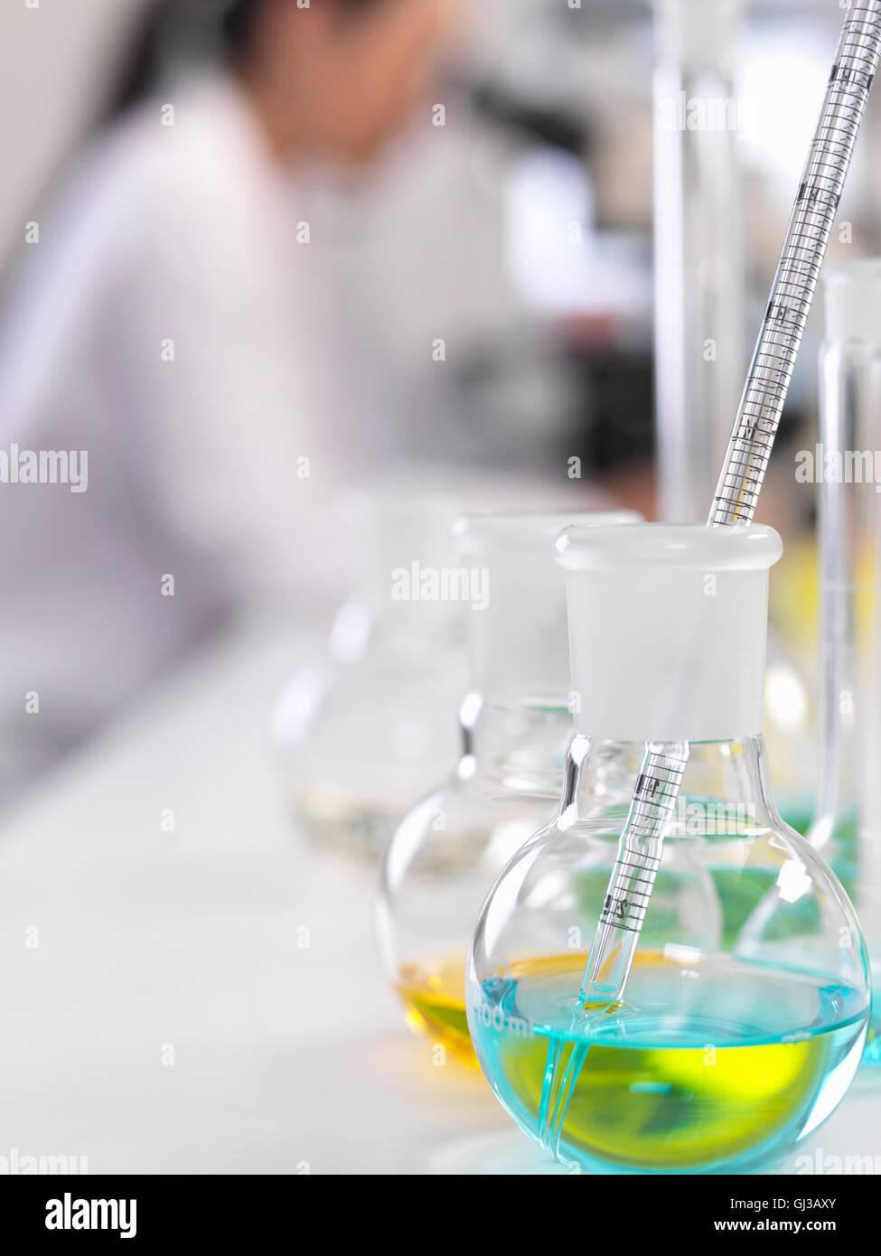 A scientist looking down a microscope with a chemical formula in the ...