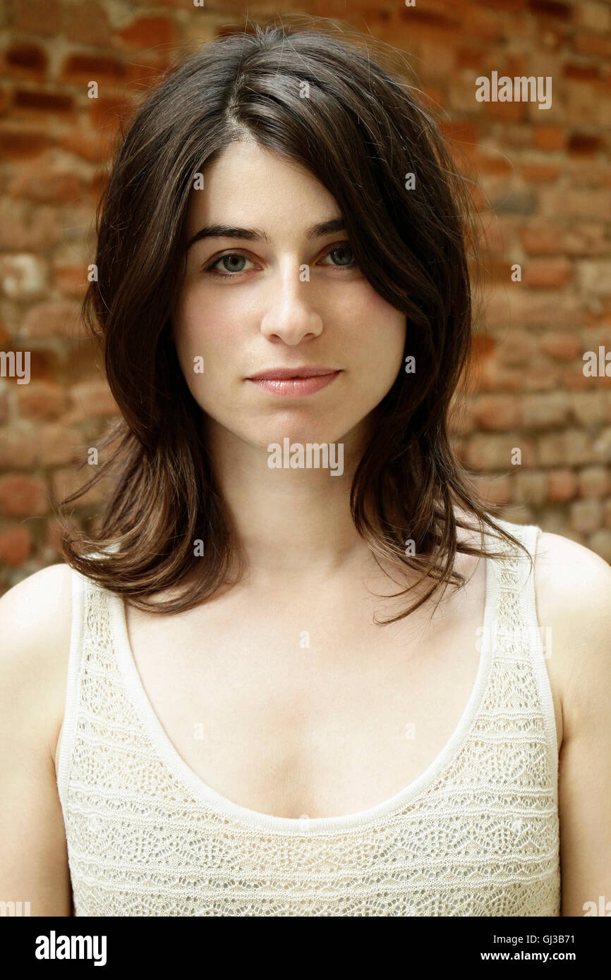 Portrait of beautiful Italian woman in front of brick wall, Milan ...