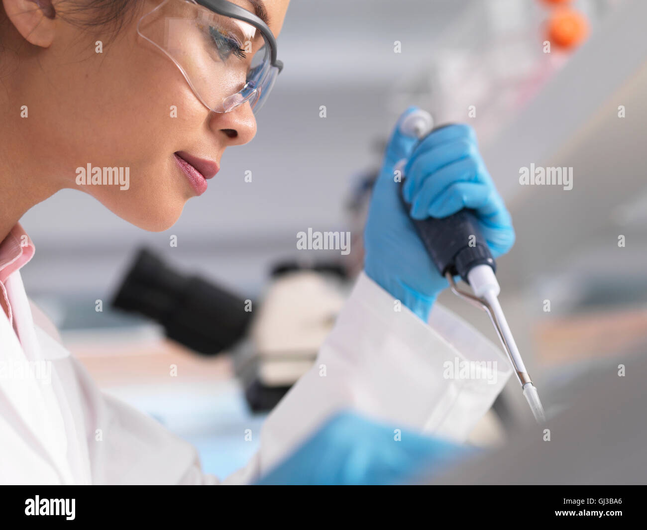 Scientist pipetting a sample into a phial during an experiment in a ...