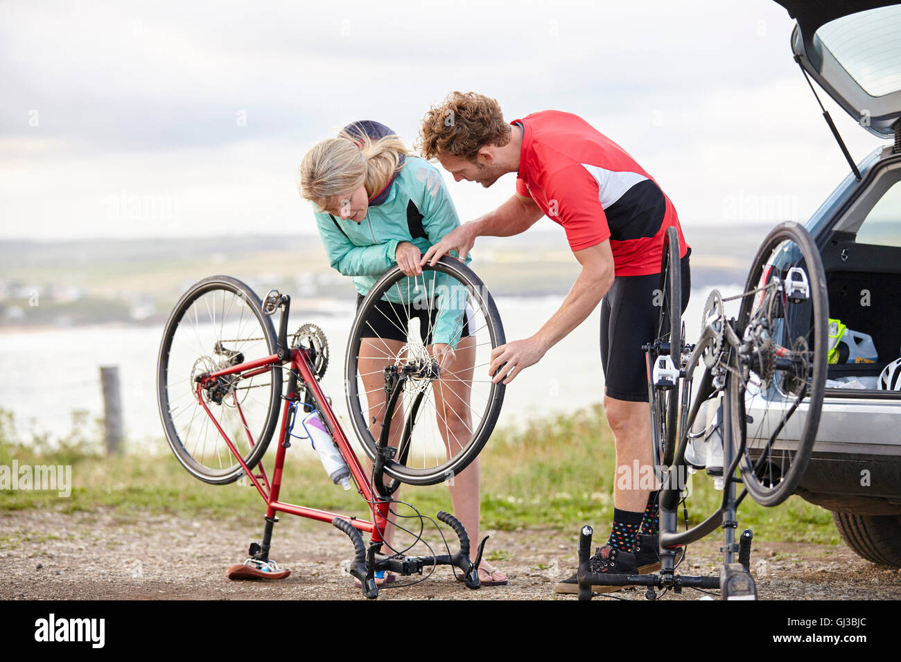 Cyclists preparing bicycle for ride Stock Photo - Alamy