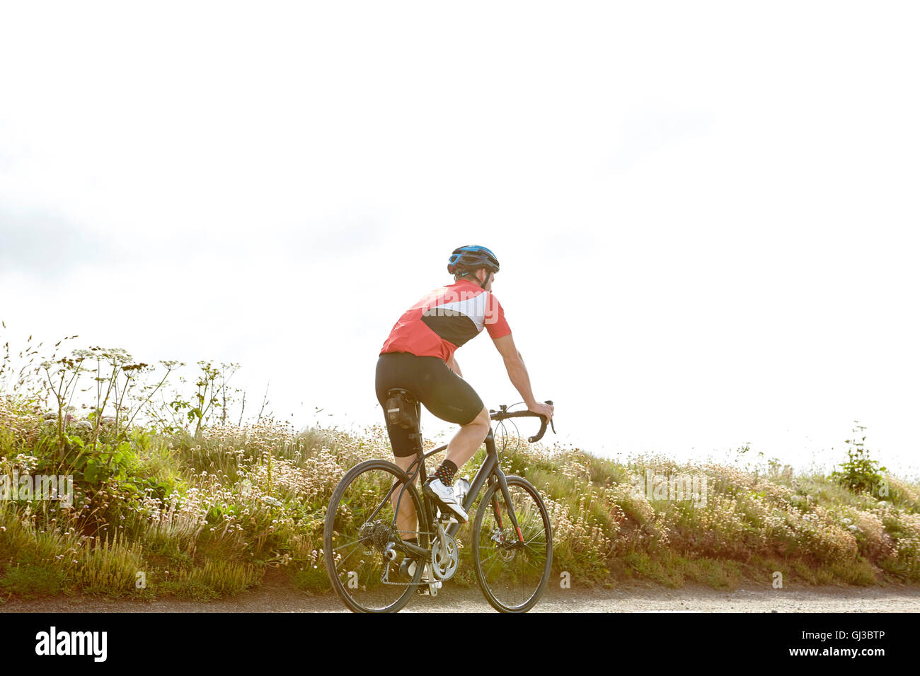 Cyclist riding on country road Stock Photo - Alamy