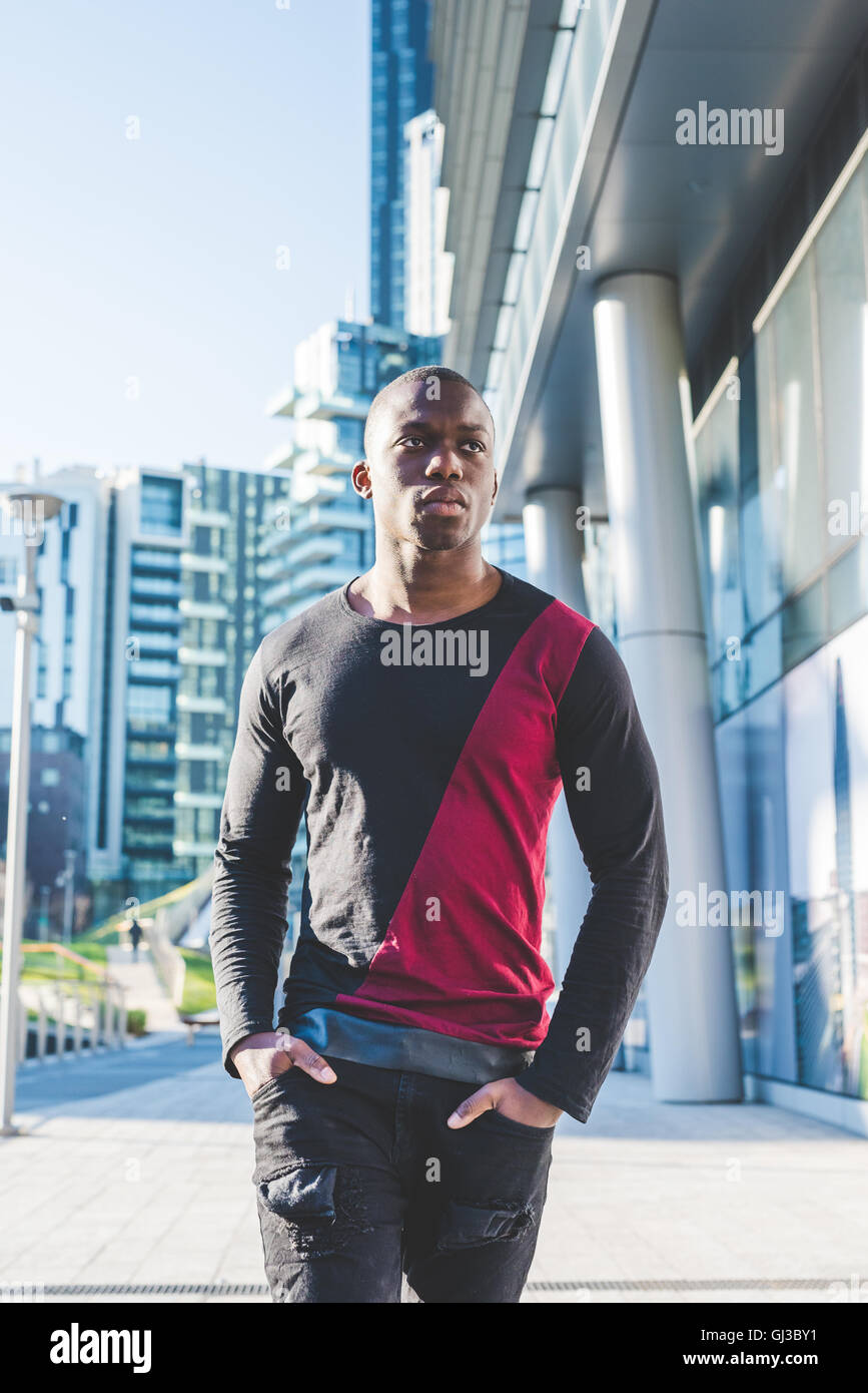 Young man walking along street, hands in pockets Stock Photo - Alamy