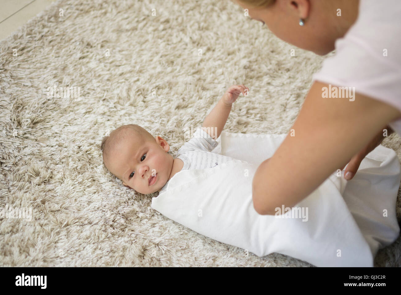 Swaddling Step 4. Mother wrapping baby boy with blanket Stock Photo - Alamy