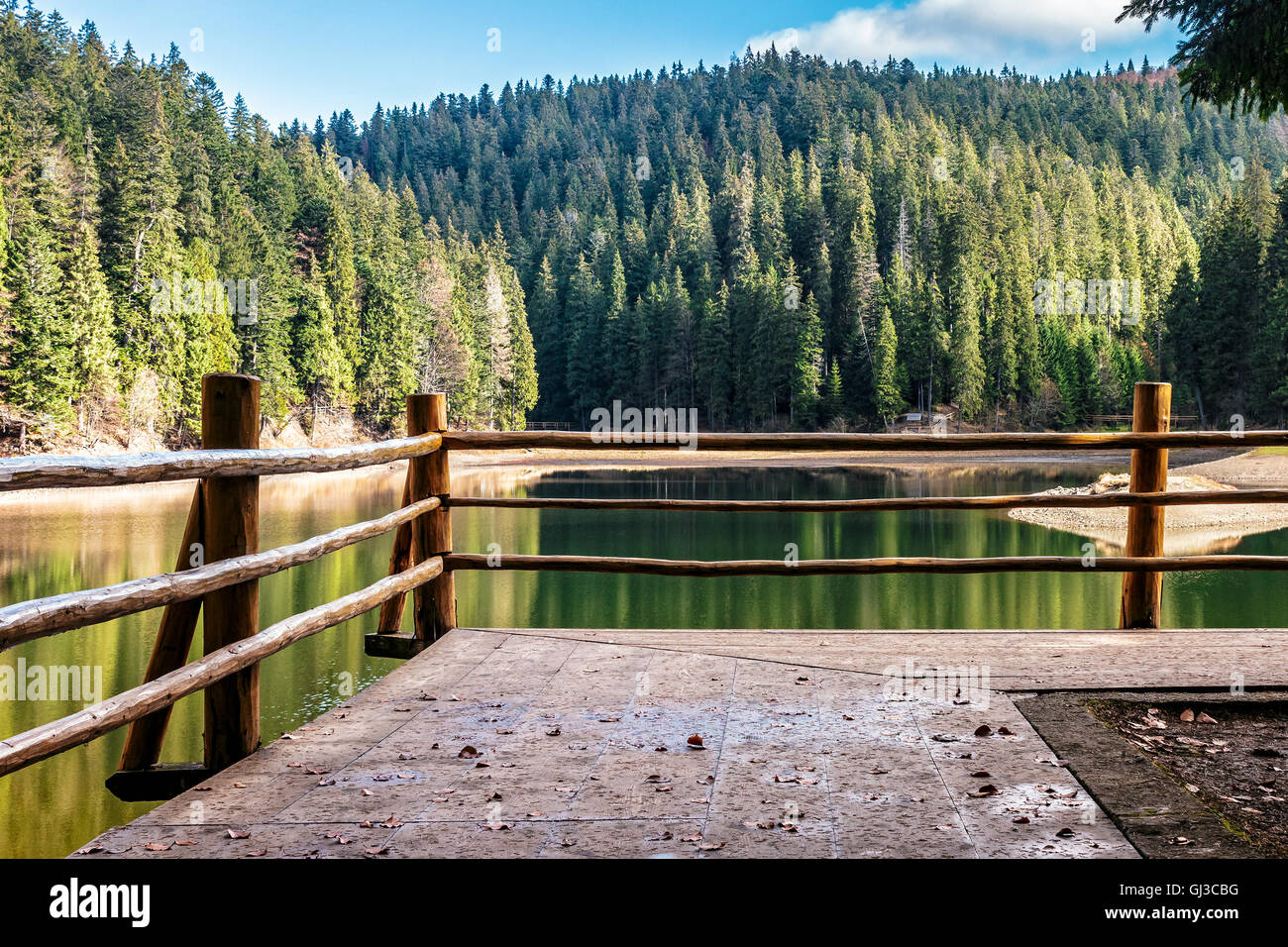 fence of wooden pier on the lake among spruce forest in mountains Stock ...
