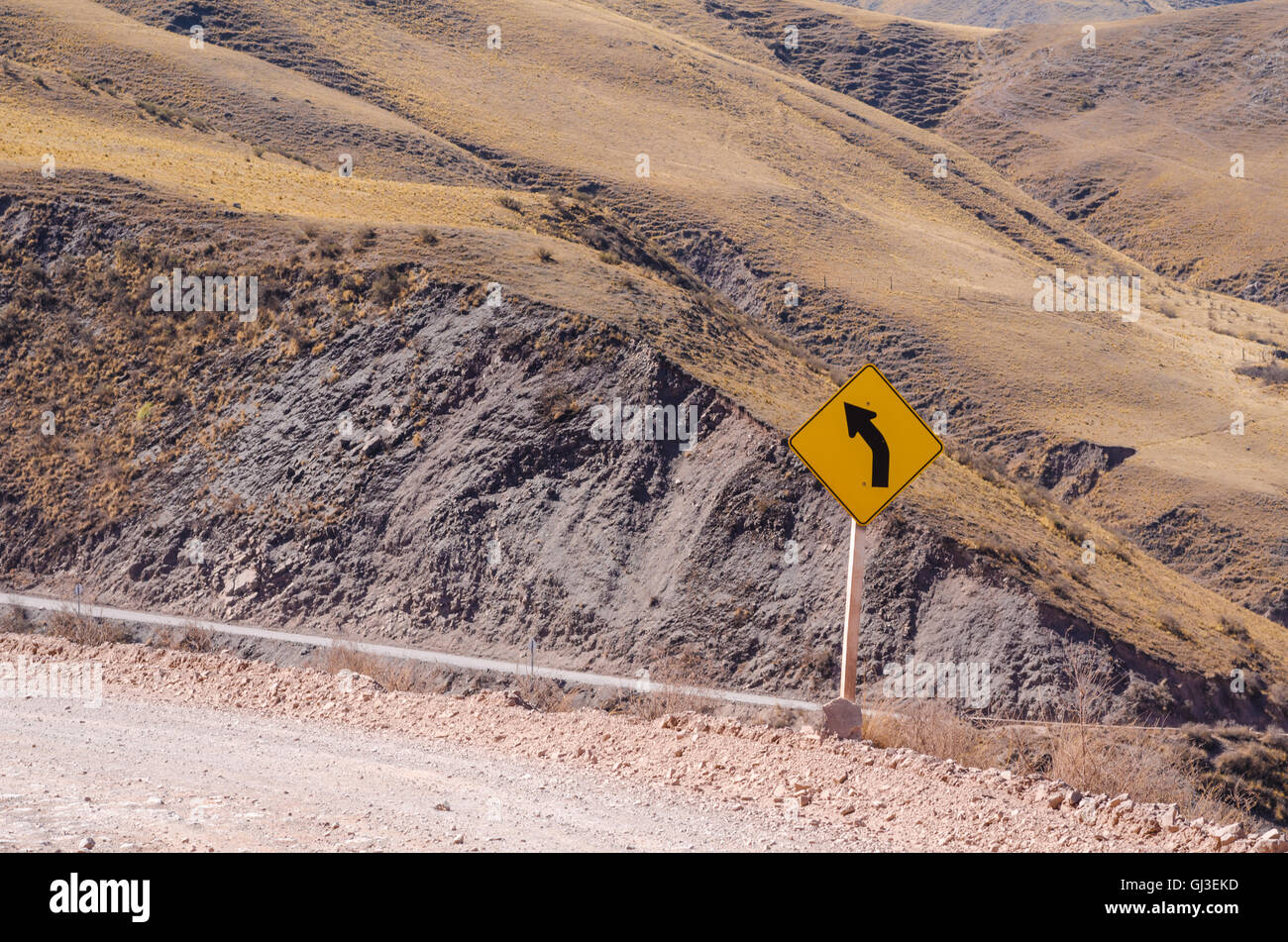 Sign warning of a dangerous bend on an Andean road Stock Photo - Alamy