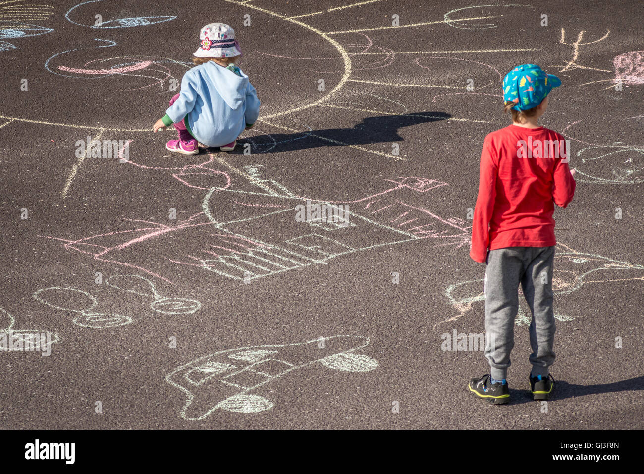 Two children drawing with chalk children activity playing outdoors ...