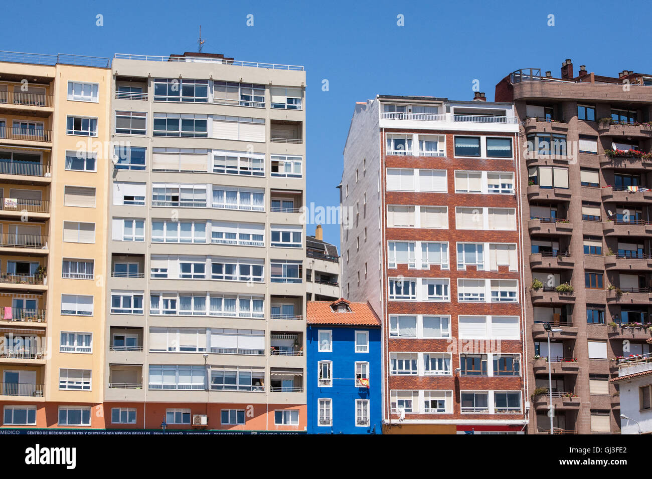 Colourful small short house in between large apartment buildings in ...