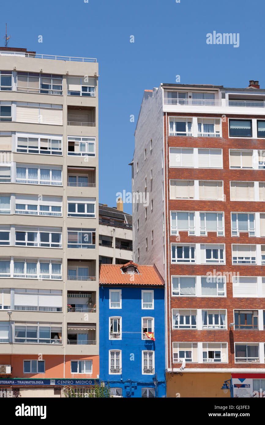 Colourful small short house in between large apartment buildings in ...